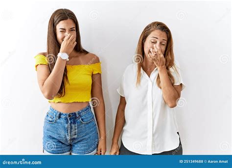 Mother And Daughter Together Standing Together Over Isolated Background Smelling Something