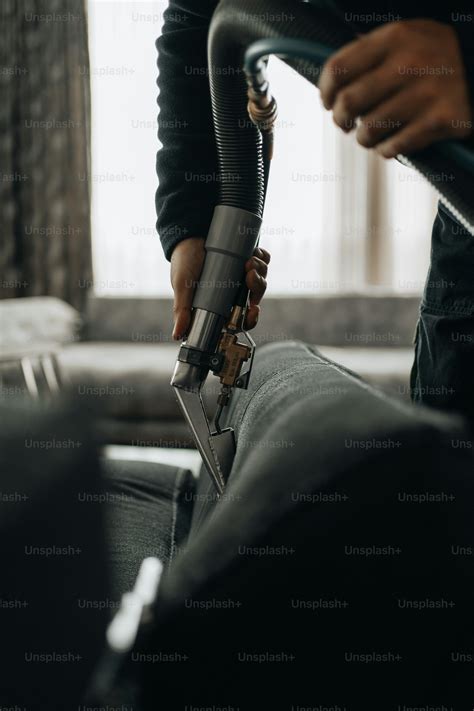 진공 청소기를 사용하여 소파를 청소하는 사람 사진 Unsplash의 딥 클리닝 이미지