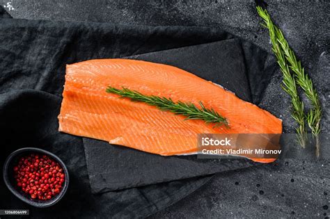 로즈마리와 핑크 페퍼를 곁들인 생 연어 필레 유기농 생선 검은 색 배경입니다 맨 위 보기 건강한 식생활에 대한 스톡 사진 및