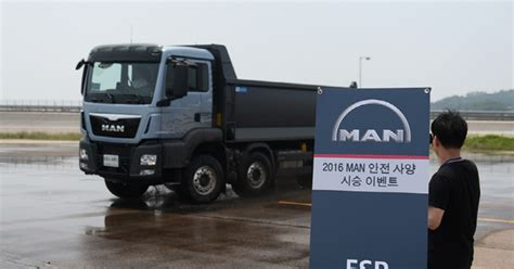 포토 젖은 노면 위에서 기민하게 움직이는 만의 덤프 트럭