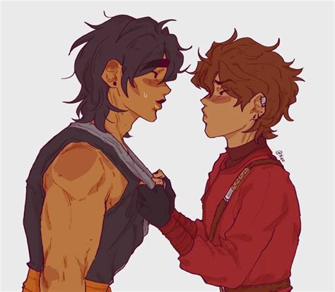 Two Young Men Standing Next To Each Other With One Touching The Others Hand