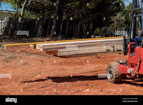 Using Lift Manipulator Construction Site Worker Unloads Delivery Of Wooden Building Material