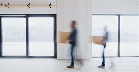 새 집을 꾸밀 때 골판지 상자를 들고 걷는 알아볼 수없는 남자 의도적인 모션 블러 사진 Unsplash의 성인 이미지