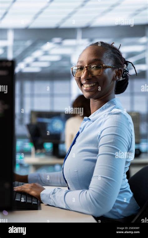 Portrait Of Smiling Technician In Data Center Coordinating Deployment Of Server Architecture