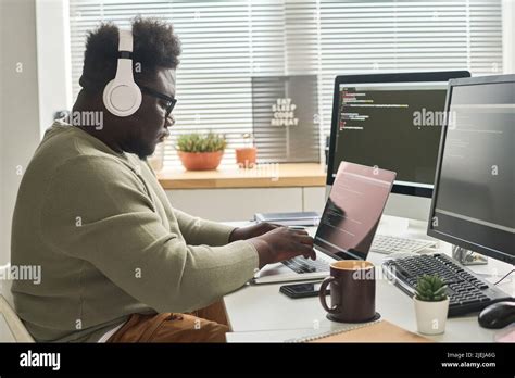 African It Programmer In Wireless Headphone Concentrating On His Online
