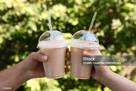 야외에서 맛있는 아이스 커피의 플라스틱 테이크아웃 컵으로 건배하는 남자와 여자 근접 촬영 응원함에 대한 스톡 사진 및 기타