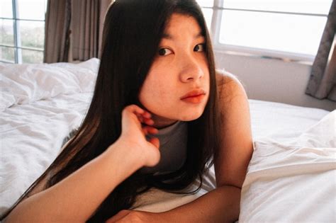 Young Woman Sitting On Bed At Home Premium Photo