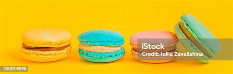 달콤한 아몬드 다채로운 유니콘 핑크 블루 옐로우 그린 마카롱 또는 마카롱 디저트 케이크는 트렌디 한 노란색 현대 패션 배경에 고립 프렌치 스위트 쿠키 최소한의 식품 베이커리