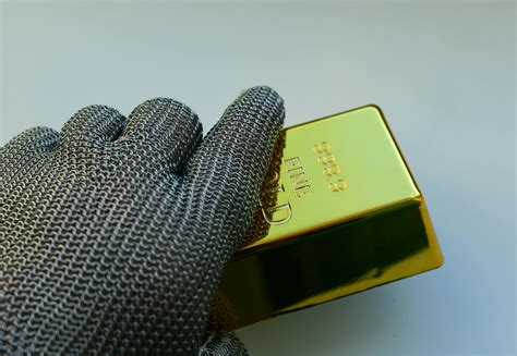 금괴를 잡고 있는 보호용 장갑을 낀 손 · 무료 스톡 사진