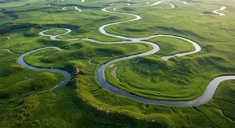 Aerial View Of A Meandering River Winding Through Lush Green