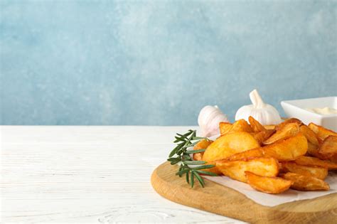 구운 감자 웨지 마늘 로즈마리 파란색 배경에 대한 부엌 보드에 흰색 소스 텍스트 공간 조각 근접 촬영 0명에 대한 스톡 사진 및 기타 이미지 Istock