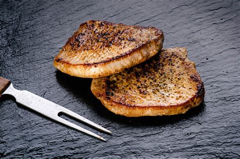 구운된 돼지고기 볶음 블랙 슬레이트에 포크로 스테이크 거품과 신선한 고기입니다 어두운 배경입니다 구이 및 바베 큐 개념 가금류에 대한 스톡 사진 및 기타 이미지 Istock