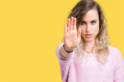 중지 하 고 격리 된 배경 위에 아름 다운 젊은 금발 여자는 손의 종 려를 가진 노래 얼굴에 부정적이 고 심각한 제스처와 경고 식입니다 거절에 대한 스톡 사진 및 기타