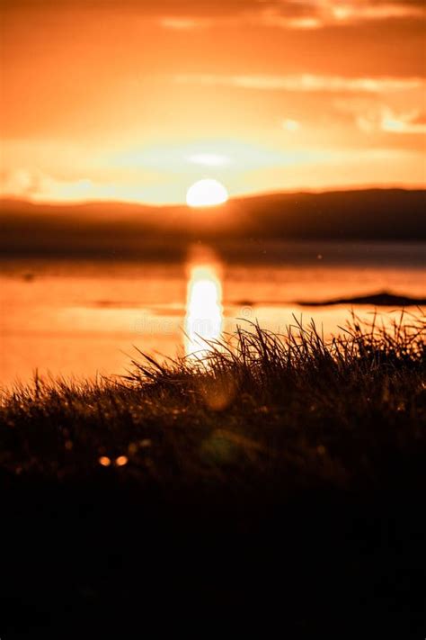 Vertical Shot Of A Bright Orange Sunset Sky Over The Water In Isle Of