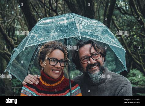 Relationship And Love Couple Under The Rain Smiling And Enjoying