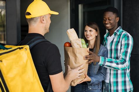 열 배낭을 가진 행복한 음식 배달 남자는 신선한 야채 주문이 든 종이 봉지를 배달합니다 25 29세에 대한 스톡 사진 및 기타 이미지 25 29세 30 34세 가방
