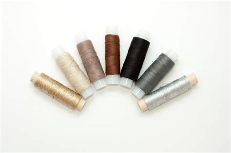 편평한 누워 다채로운 면 스레드 스풀 자 수 원사 흰색 갈색 회색 검정색 은색 금색의 바비 위로 모의 상단 보기 레이아웃 이랑 바느질 바느질 포스터 배너에 대 한 빈 흰색