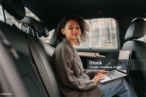 사무실로 가는 길에 자동차 가죽 뒷좌석에 앉아 노트북을 작업하는 웃는 사업가 분석가 25 29세에 대한 스톡 사진 및 기타 이미지 25 29세 교통수단 낮 Istock