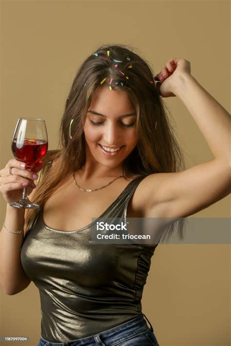 황금 셔츠 춤과 레드 와인 한 잔을 들고 매력적인 여자 색종이로 파티를 즐기는 행복한 젊고 아름다운 여성 가냘픈에 대한 스톡 사진 및 기타 이미지 Istock