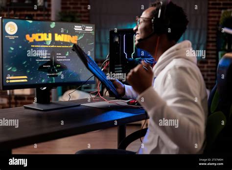 Gamer Playing Intense Classic Arcade Spaceship Racing Videogame Throwing Fist Up In Air In