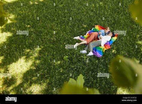 Two Lesbians Lying On Green Grass And Enjoying Each Other Outdoors In