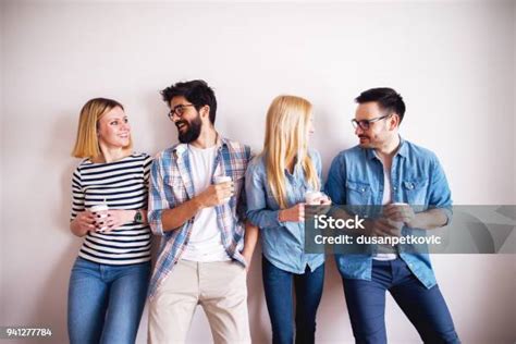 종이 컵에 마시는 커피와 휴식에 대 한 얘기는 벽에 서 있는 젊은 동료 사람들의 그룹입니다 동료에 대한 스톡 사진 및 기타 이미지 Istock