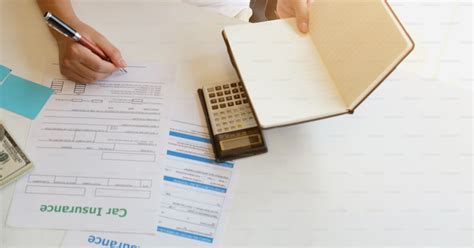 위의 평면도는 보험 자동차 및 건강 선택 초점의 금융과 함께 테이블에서 작업하는 에이전트 보험의 잘린 샷입니다 사진 Unsplash의 상인 이미지