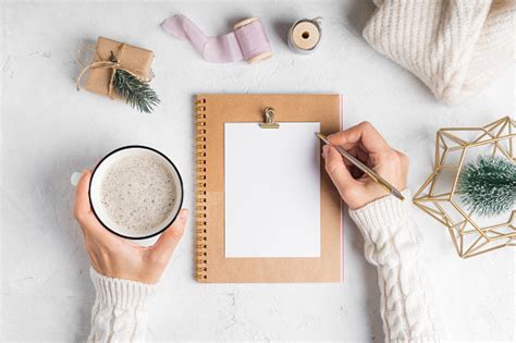 데스크톱 빈 플래너 커피와 크리스마스 장식 한 잔흰색 작업 테이블 배경의 평평한 평지 상단 보기 공 전나무 나무 종이 클립 인사말 카드 공예 노트북 및 펜을 모의 12월에