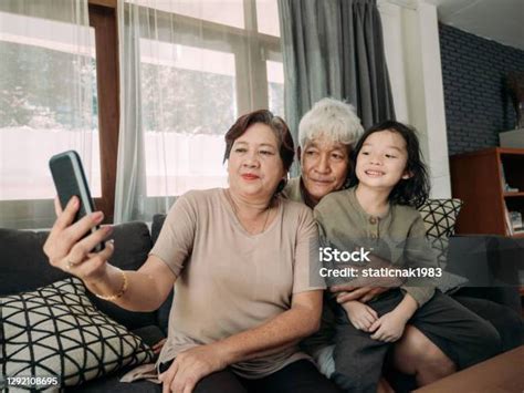 Dewasa Senior Mengambil Selfie Dengan Cucu Di Sofa Di Rumah Foto Stok Unduh Gambar Sekarang