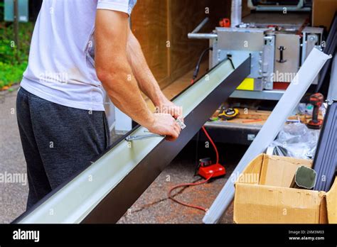 An Employee Is Installing Hidden Gutter Hangers With Pre Installed