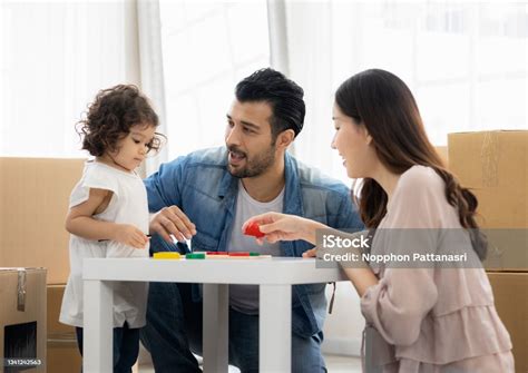 부모와 딸들은 집 안 거실 바닥에 나무 블록이 앉아 놀고 있습니다 가족은 방금 새 집으로 이사했습니다 행복한 순간 다민족 아빠 엄마와 아이 가족에 대한 스톡 사진 및 기타