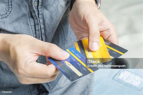 남자는 여러 개의 신용 카드를 들고 신용 카드를 통해 상품에 대한 지불을 지불하고 지출 할 신용 카드를 선택하고 있습니다 금융 및 은행 개념 개념에 대한 스톡 사진 및 기타