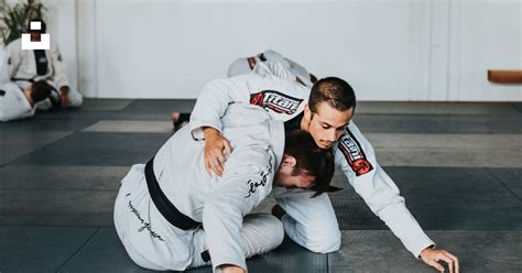 흰색과 검은색 재킷과 바지를 입은 남자가 검은 바닥에 앉아 있다 사진 Unsplash의 무료 무술 이미지