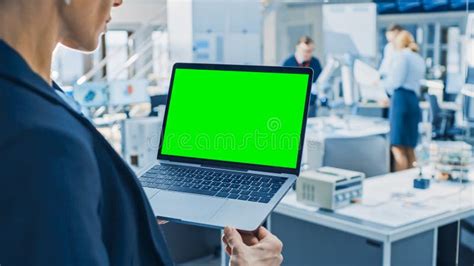 Engineer Holds Green Mock Up Screen Laptop Computer In The Background Team Of Industrial