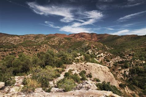 Landscape Of Rocky Cliffside Path Overlooking Lush Green Valley With