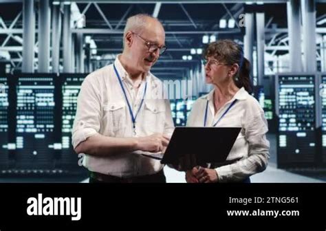 Coworkers In Data Center Using Laptop To Monitor Energy Efficient