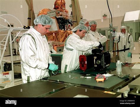 At A Work Bench In The Spacecraft Assembly And Encapsulation Facility 2 Workers Test The