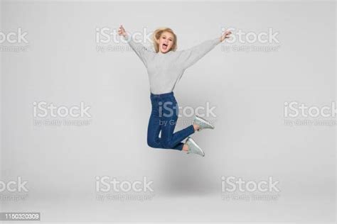 쾌활 한 젊은 여자 점프와 회색 배경 위에 축 하의 전체 길이 초상화 귀여운에 대한 스톡 사진 및 기타 이미지 귀여운