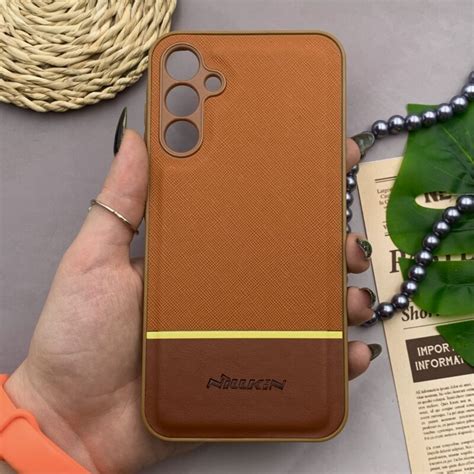 قاب گوشی Galaxy A15 سامسونگ چرمی Nillkin سوزنی دور سیلیکونی محافظ لنز دار عسلی کد 64720 قاب سنتر