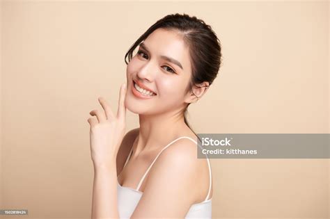 베이지 색 배경에 깨끗한 신선한 피부를 가진 아름다운 젊은 아시아 여성 얼굴 관리 얼굴 치료 화장품 아름다움과 스파 아시아 여성 초상화 20 24세에 대한 스톡 사진 및