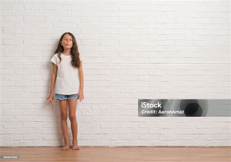 흰색 벽돌 벽 만드는 물고기 얼굴 입술 고 우 스 꽝 스러운 제스처와 함께 젊은 히스패닉 아이 Stading 재미 있는 식입니다