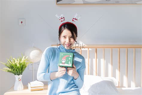 크리스마스 손은 선물 미녀로 침대에 앉아 있다 사진 무료 다운로드 Lovepik