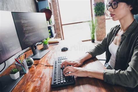 Young Female Programmer Working At A Computer Desk In A Casual Home Office Environment