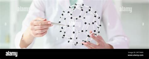 Woman Scientist Shows Model Of Molecular Structure In Her Hands Sitting At Laboratory Table