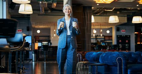 두 개의 테이크 아웃 커피 컵을 들고 카페테리아를 산책하면서 웃는 아름다운 아가씨 사진 Unsplash의 양복 이미지