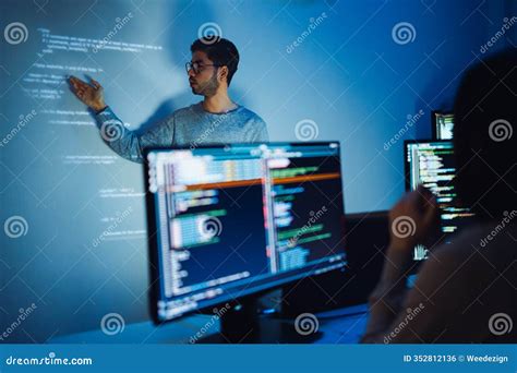 Indian Man Programmer Standing In Front Of A Screen With Code Projected