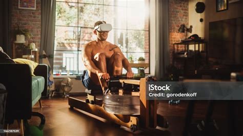 미래형 메타버스 홈 체육관 가상 현실 헤드셋을 착용하고 로잉 머신에서 운동하는 강한 운동선수 흑인 근육질의 혼혈 스포츠맨 인터넷 Vr 운동 서비스를 이용하여 건강 유지 로잉