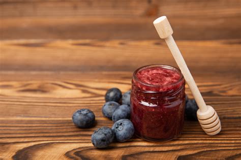 갈색 나무에 블루베리와 라즈베리를 곁들인 꿀 항아리 감기약 건강과 미용을위한 유용한 강화 잼 크림 꿀 채식주의 식단 유기농 제품 복사 공간 텍스트 배치 0명에 대한 스톡