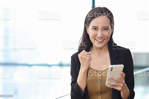 자신감 넘치는 젊은 아시아 사업가들이 현대적인 사무실 건물과 도시 배경에서 비즈니스 미팅에서 스마트폰을 사용하면서 행복한 웃는 얼굴로 일을 연구하고 계획하는 초상화 35