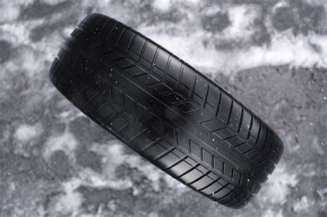 자동차 휠 타이어는도 서 서 개념 겨울 타이어입니다 눈에 덮인 백그라운드와 겨울 타이어입니다 로로에 디스크 서의 자동차 타이어